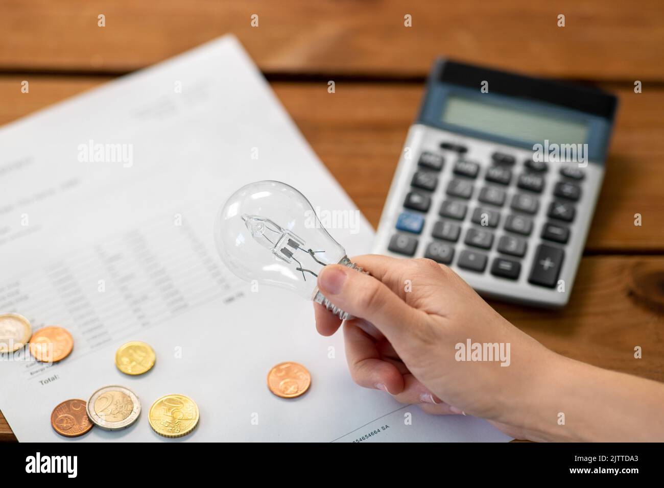 hand with lightbulb, bill, calculator and money Stock Photo - Alamy