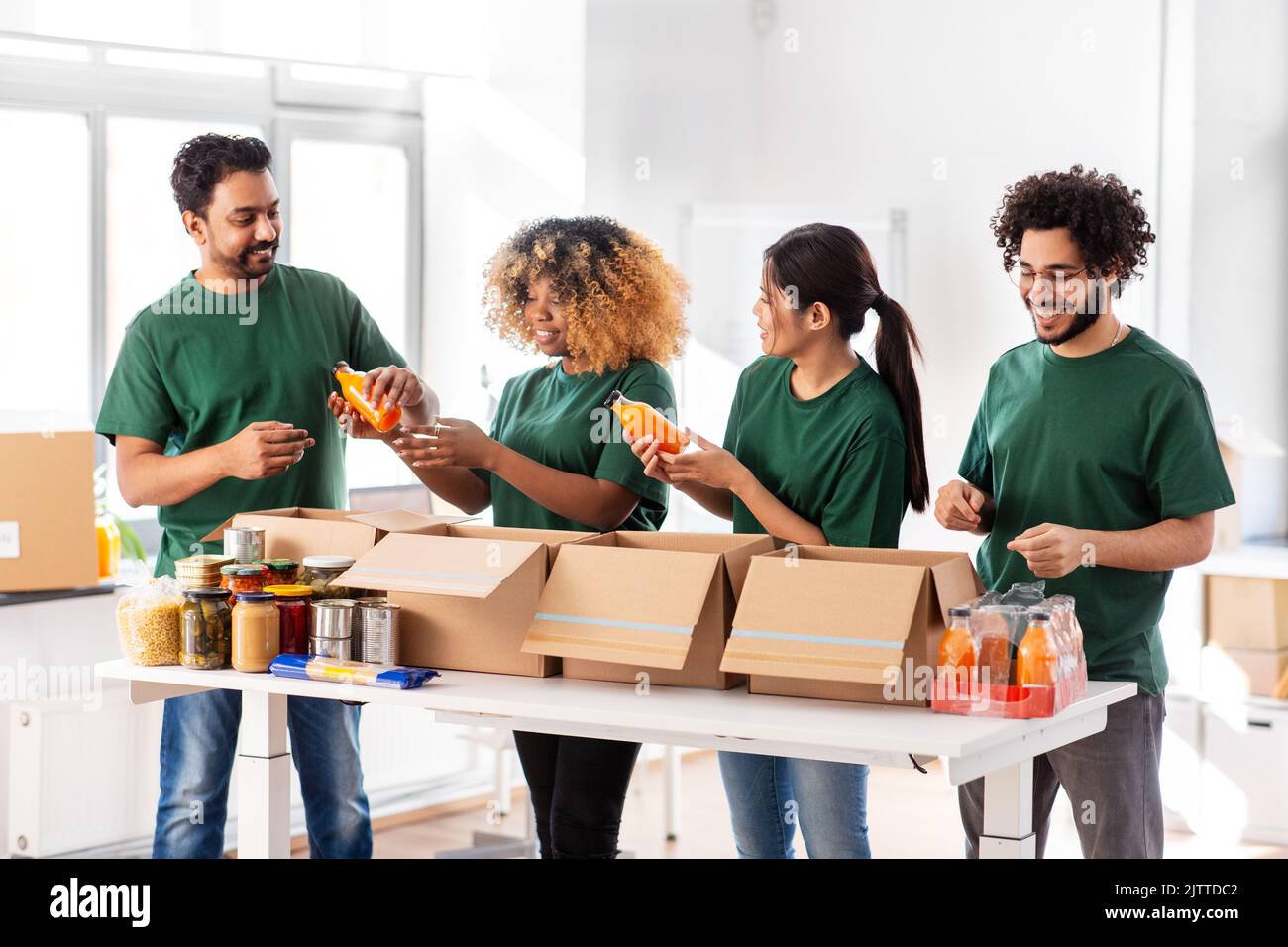 happy volunteers packing food in donation boxes Stock Photo - Alamy