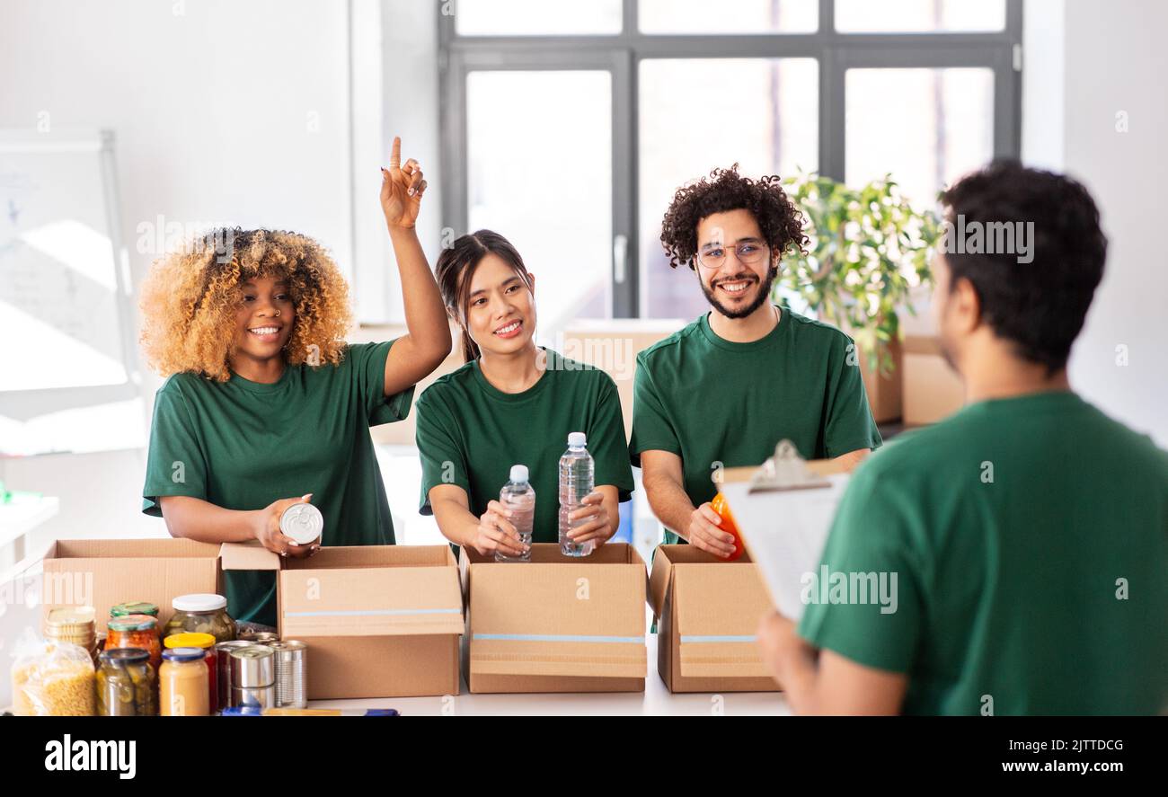 happy volunteers packing food in donation boxes Stock Photo - Alamy