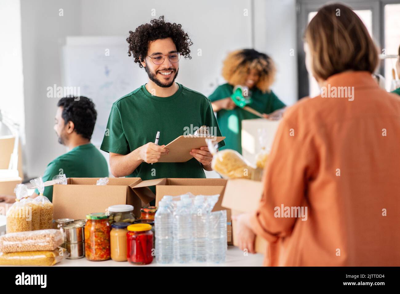 happy volunteers packing food in donation boxes Stock Photo - Alamy