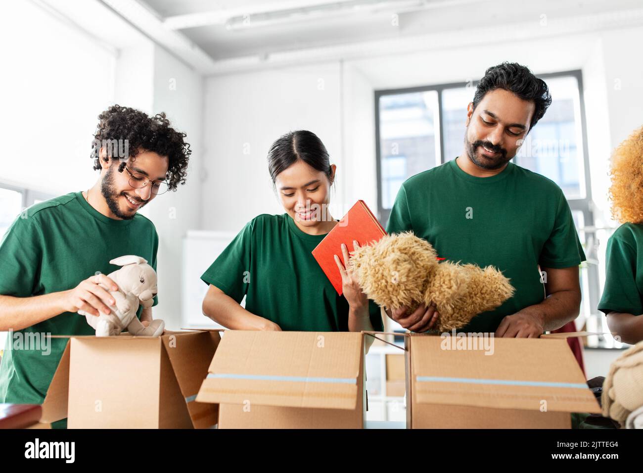 happy volunteers packing things in donation boxes Stock Photo - Alamy