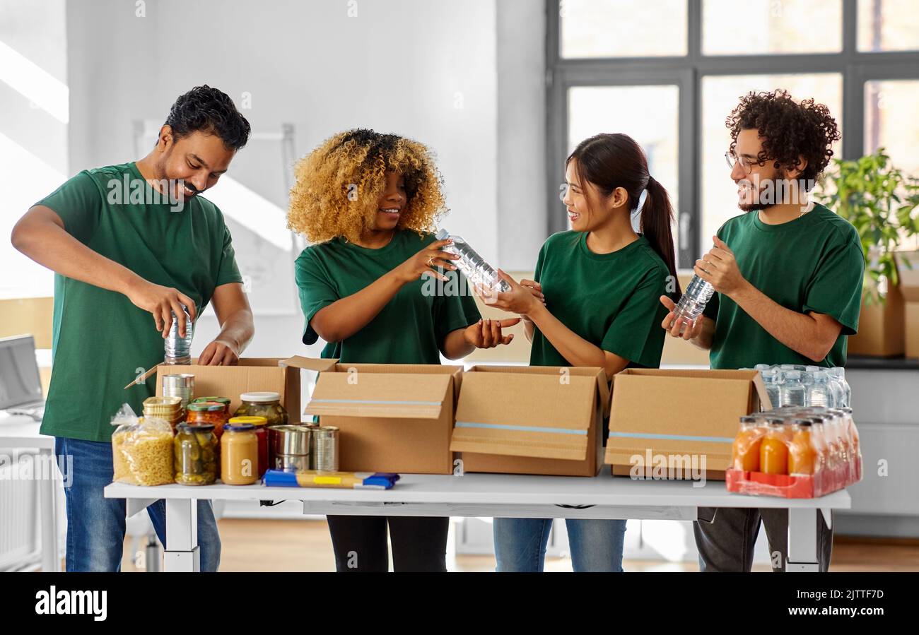 happy volunteers packing food in donation boxes Stock Photo - Alamy