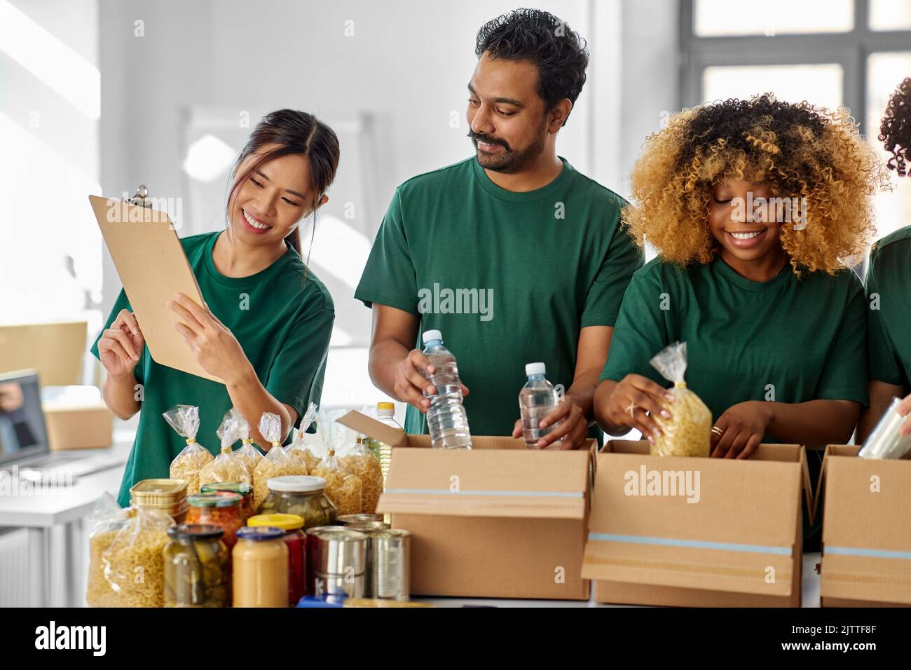 happy volunteers packing food in donation boxes Stock Photo - Alamy