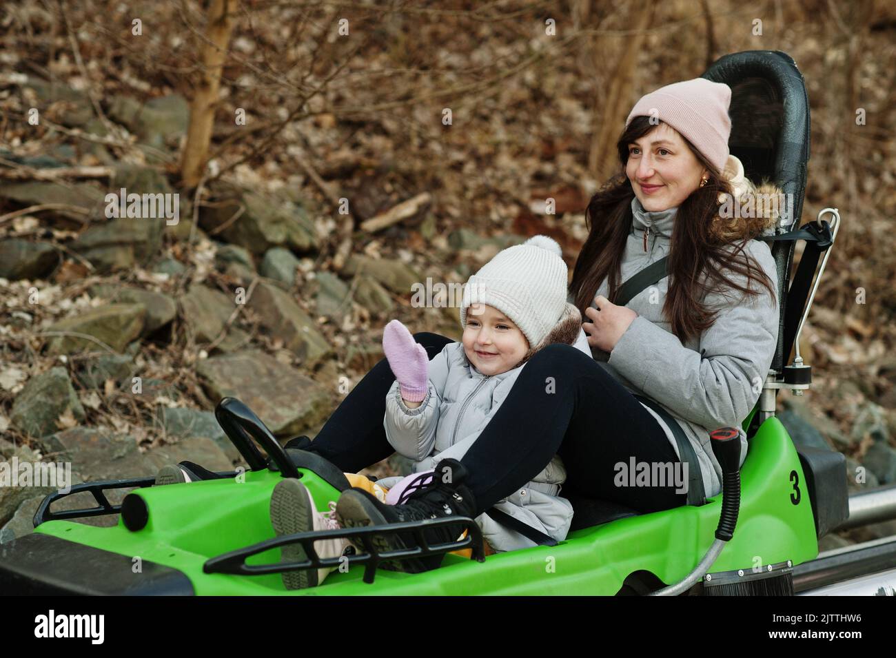 Mother with daughter ride electric sleigh on rails Stock Photo - Alamy