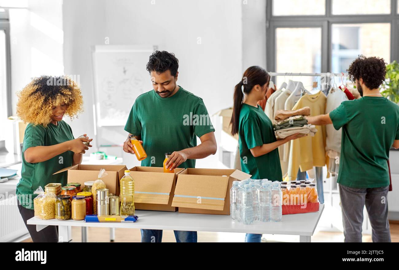 happy volunteers packing food and clothes in boxes Stock Photo - Alamy