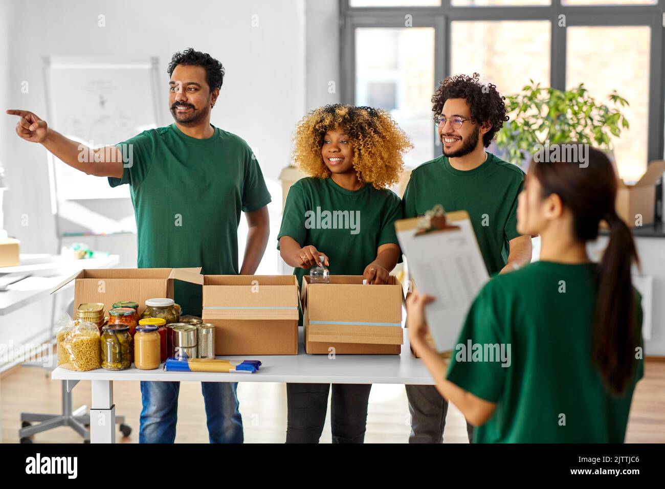 happy volunteers packing food in donation boxes Stock Photo - Alamy