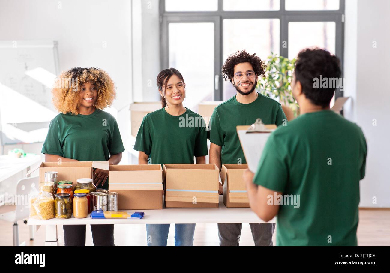 happy volunteers packing food in donation boxes Stock Photo - Alamy