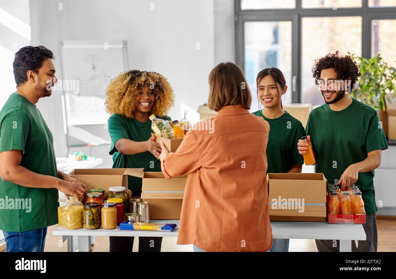 happy volunteers packing food in donation boxes Stock Photo - Alamy