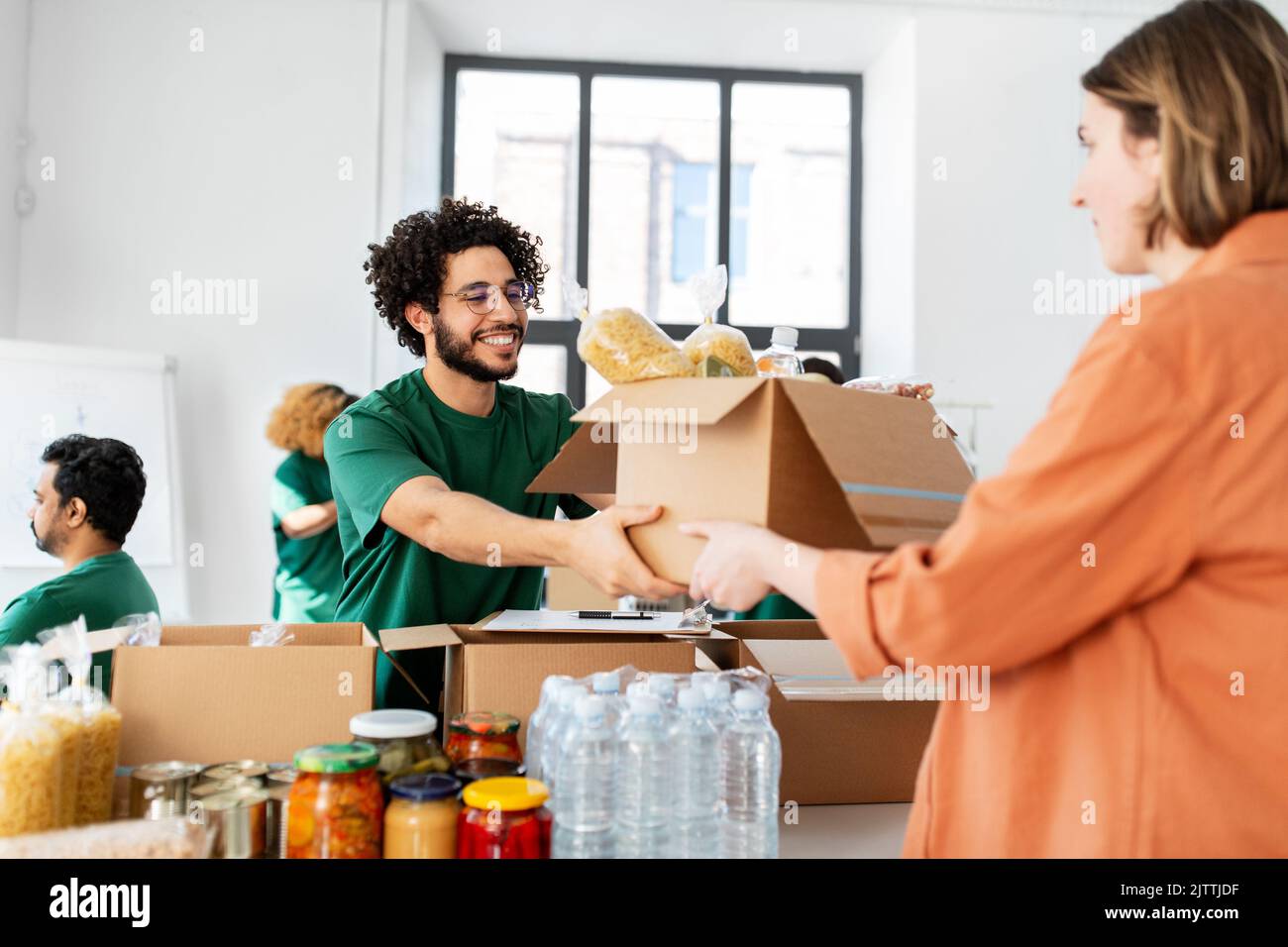 volunteer giving food at refugee assistance center Stock Photo - Alamy