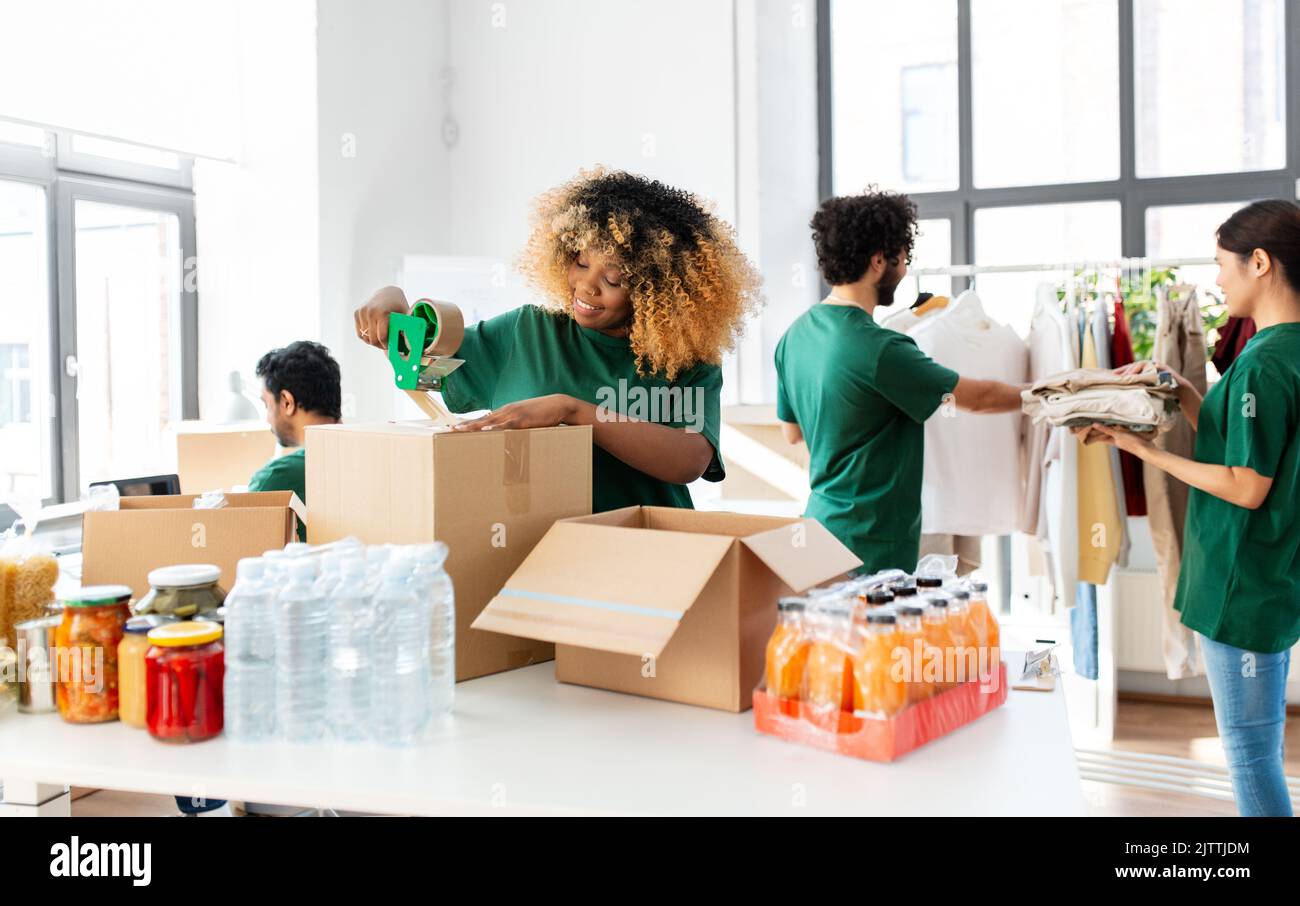 happy volunteers packing food in donation boxes Stock Photo - Alamy