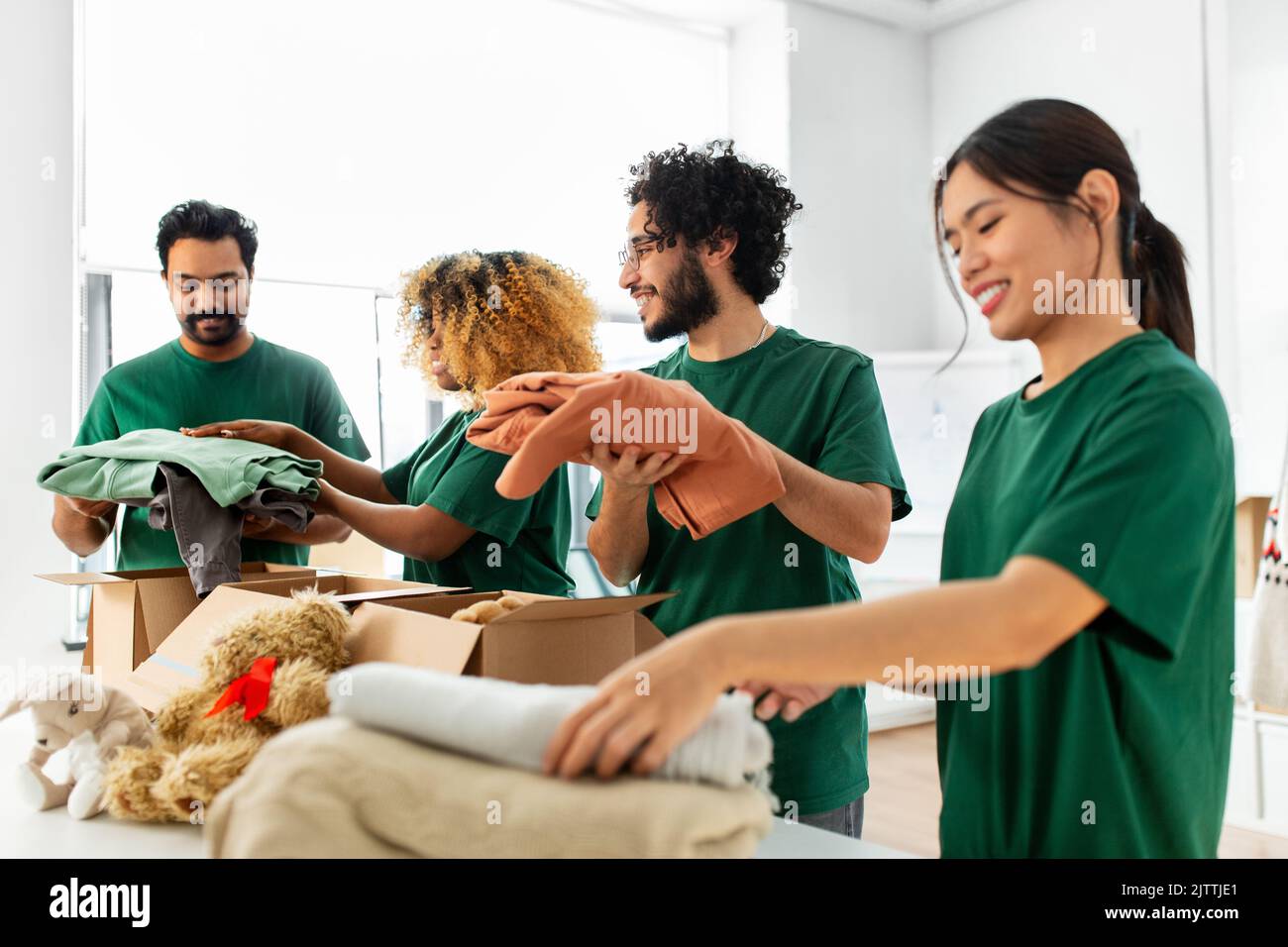 happy volunteers packing things in donation boxes Stock Photo - Alamy