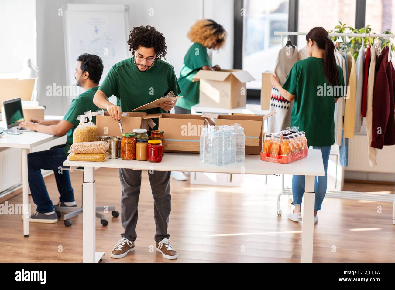 group of volunteers packing food in donation boxes Stock Photo - Alamy