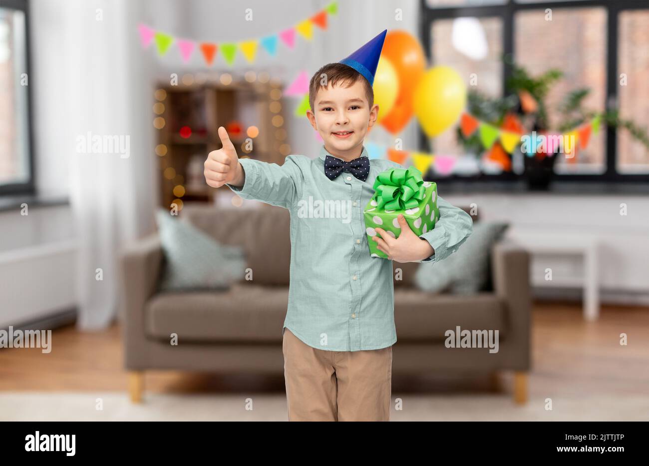 happy boy with birthday gift showing thumbs up Stock Photo - Alamy