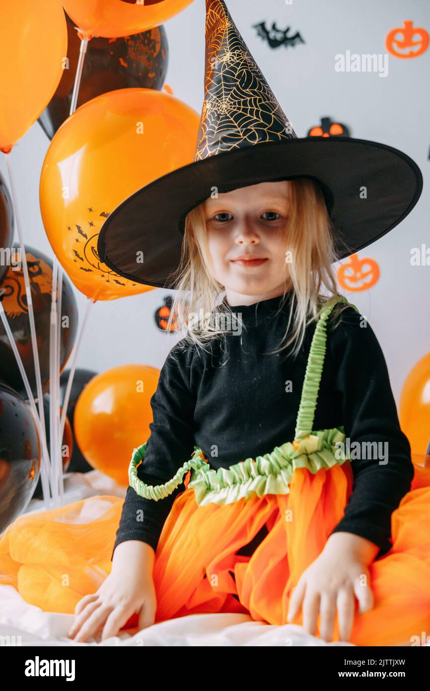 Children's Halloween - a girl in a witch hat and a carnival costume ...