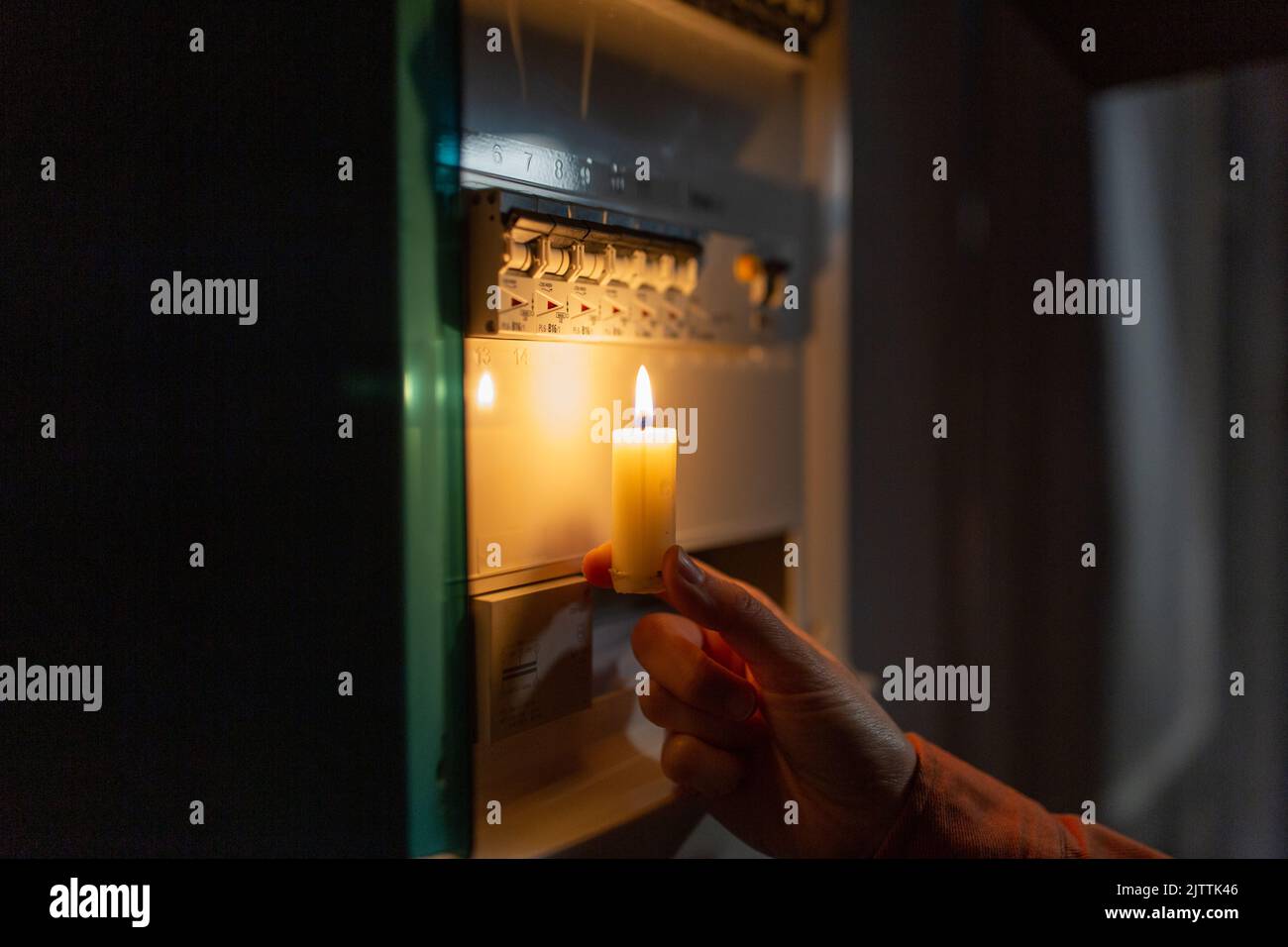hand with burning candle near electric board Stock Photo - Alamy