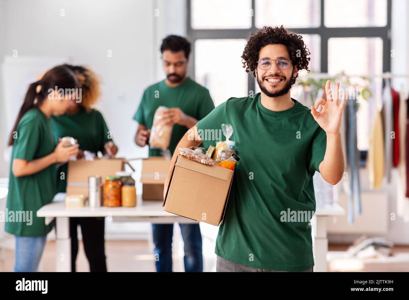 happy volunteers packing food in donation boxes Stock Photo - Alamy