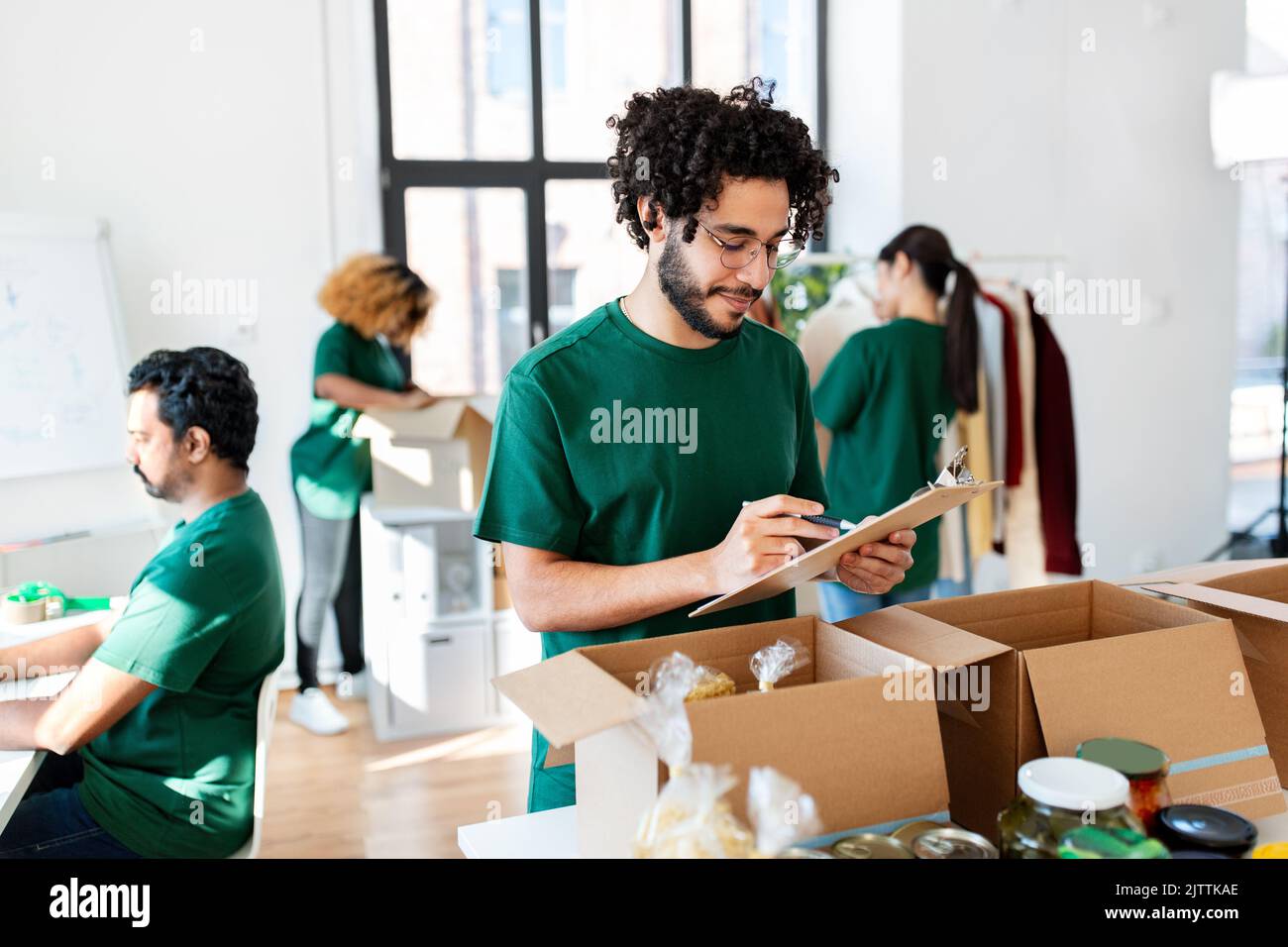 group of volunteers packing food in donation boxes Stock Photo - Alamy