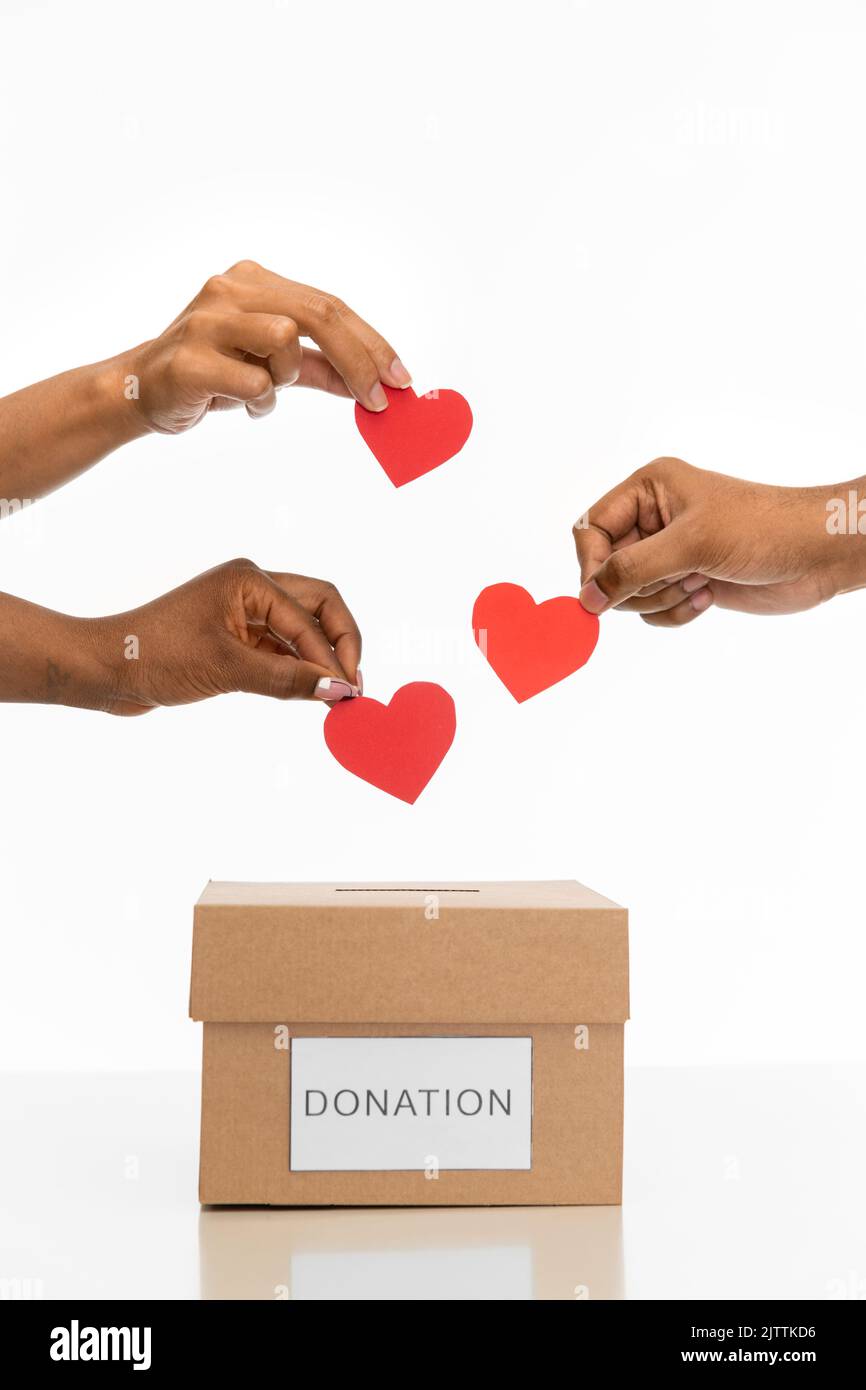 hands putting red heart into donation box Stock Photo - Alamy