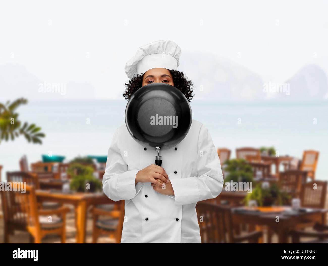 female chef peeking out from behind frying pan Stock Photo - Alamy