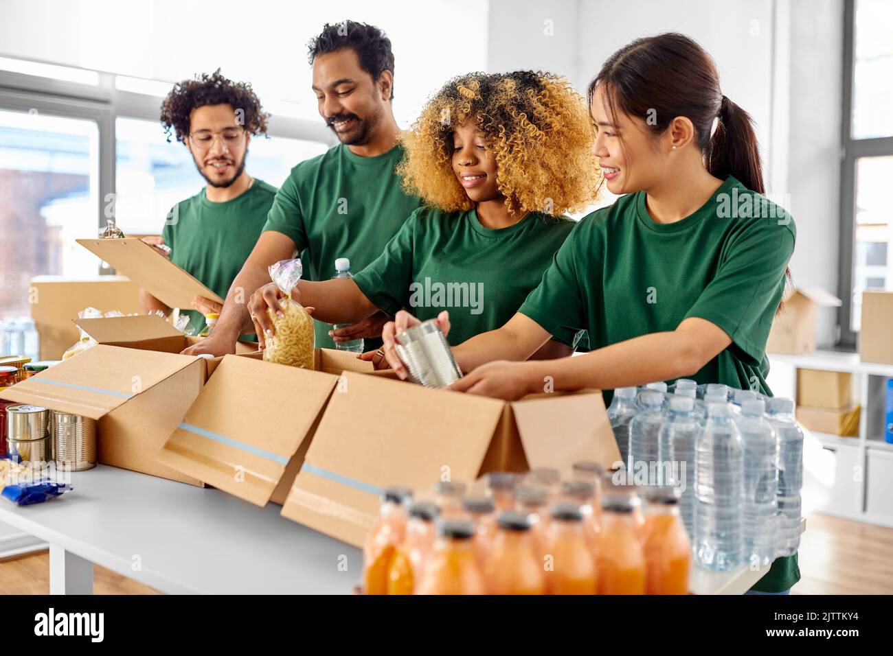 happy volunteers packing food in donation boxes Stock Photo - Alamy