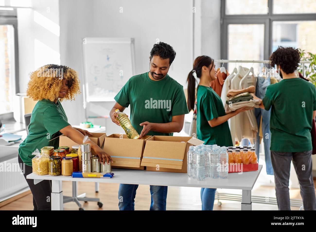 happy volunteers packing food and clothes in boxes Stock Photo - Alamy
