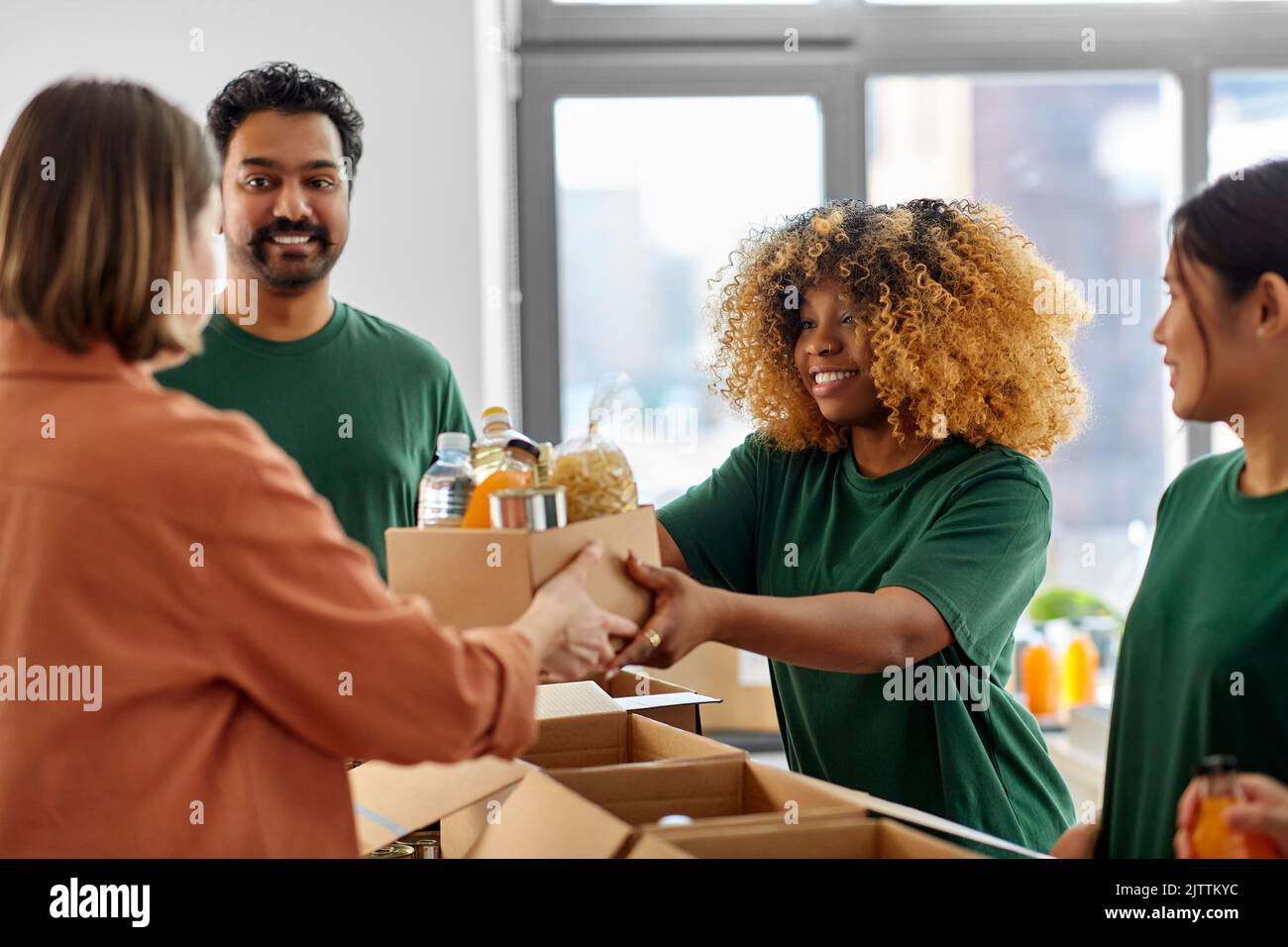 happy volunteers packing food in donation boxes Stock Photo - Alamy