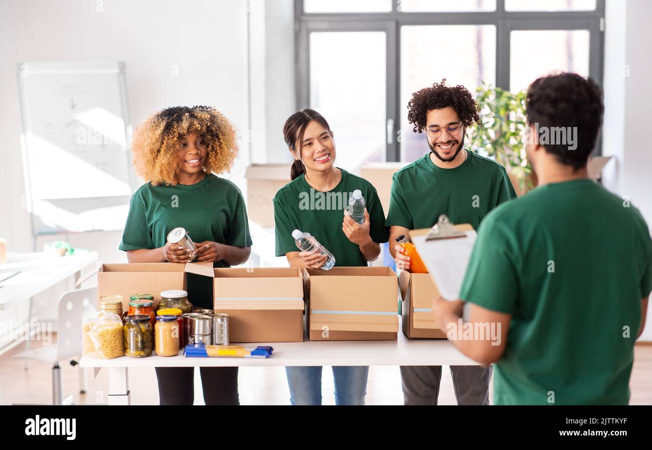 happy volunteers packing food in donation boxes Stock Photo - Alamy
