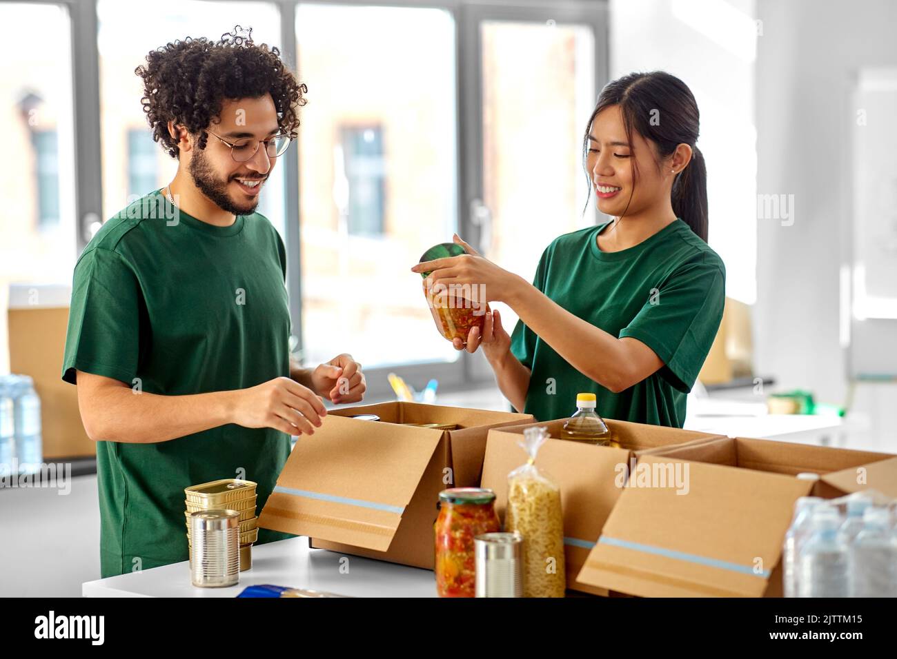 happy volunteers packing food in donation boxes Stock Photo - Alamy