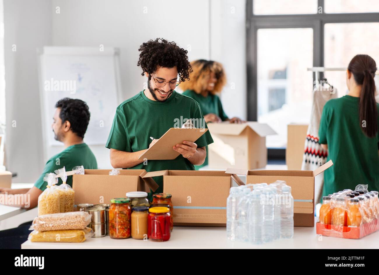 happy volunteers packing food in donation boxes Stock Photo - Alamy