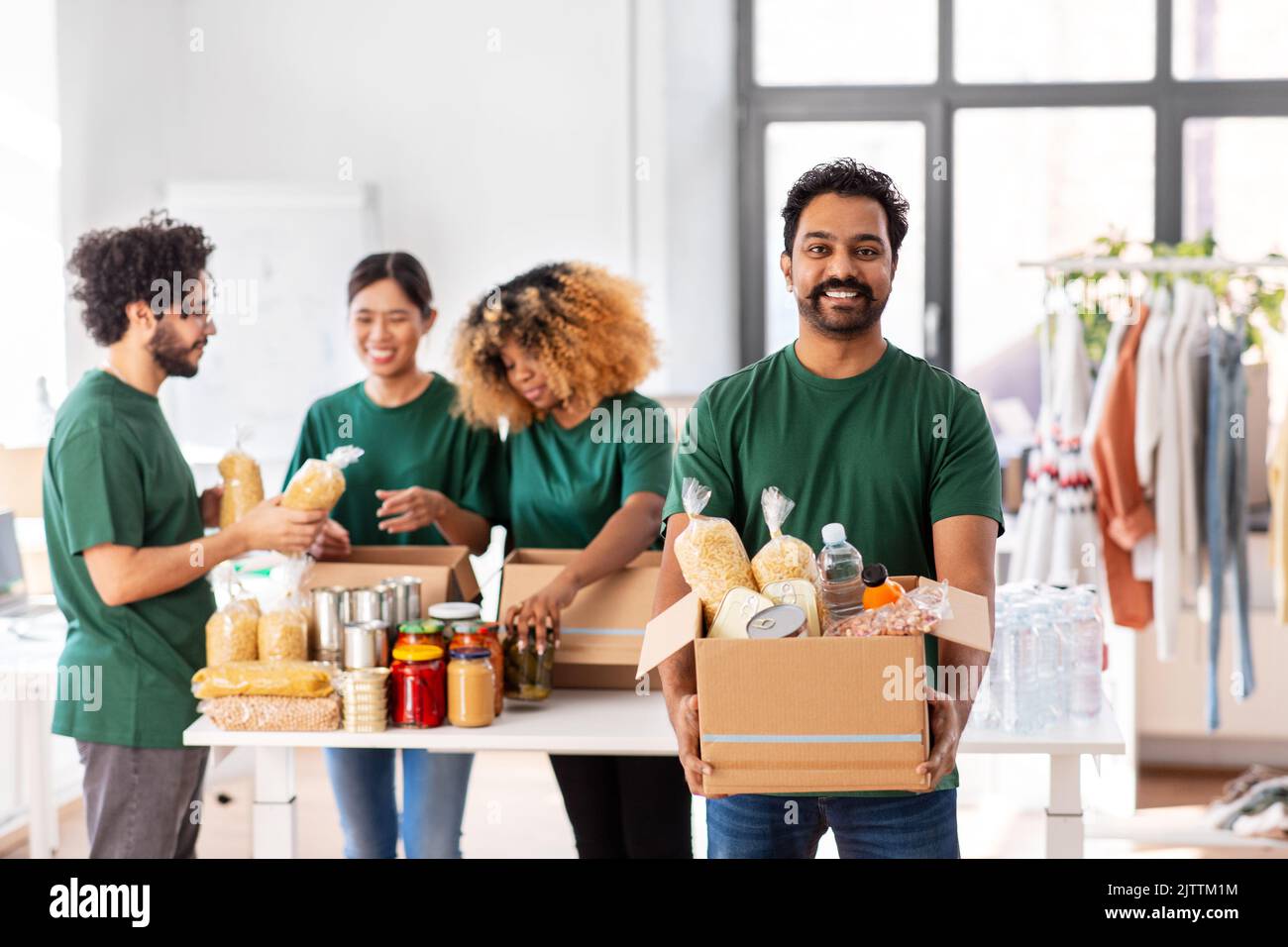 happy volunteers packing food in donation boxes Stock Photo - Alamy