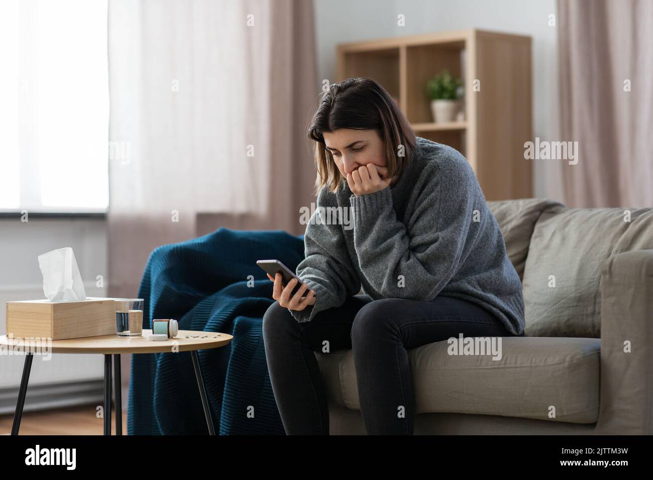 stressed woman with medicine and phone at home Stock Photo - Alamy