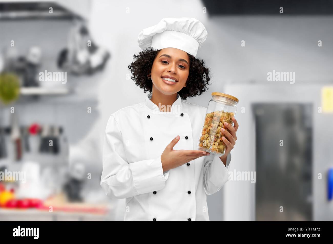 female chef holding jar with pasta in kitchen Stock Photo - Alamy