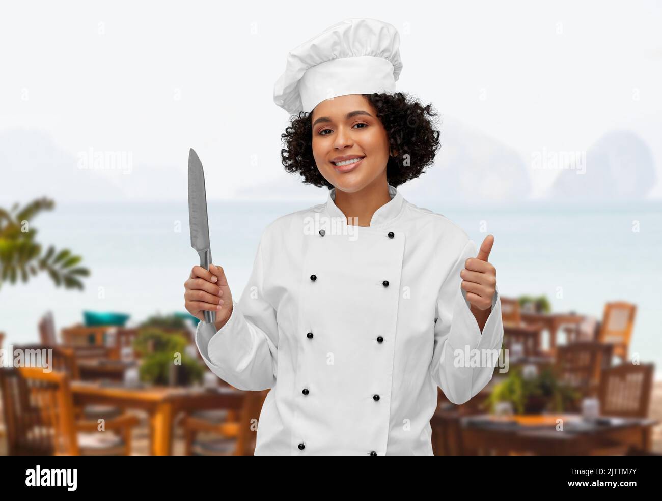 female chef in toque with knife showing thumbs up Stock Photo - Alamy