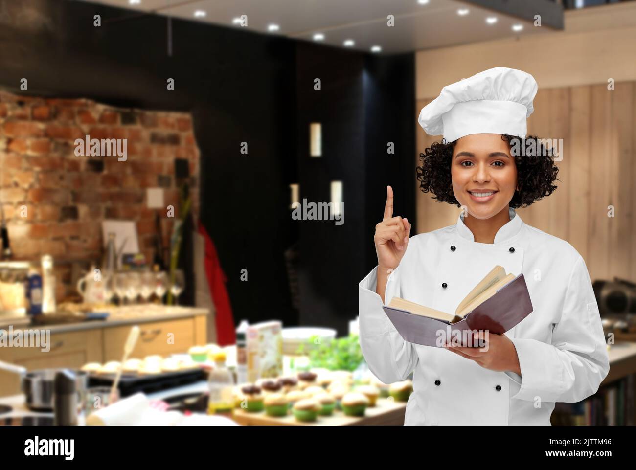 happy female chef in white toque with cook book Stock Photo - Alamy