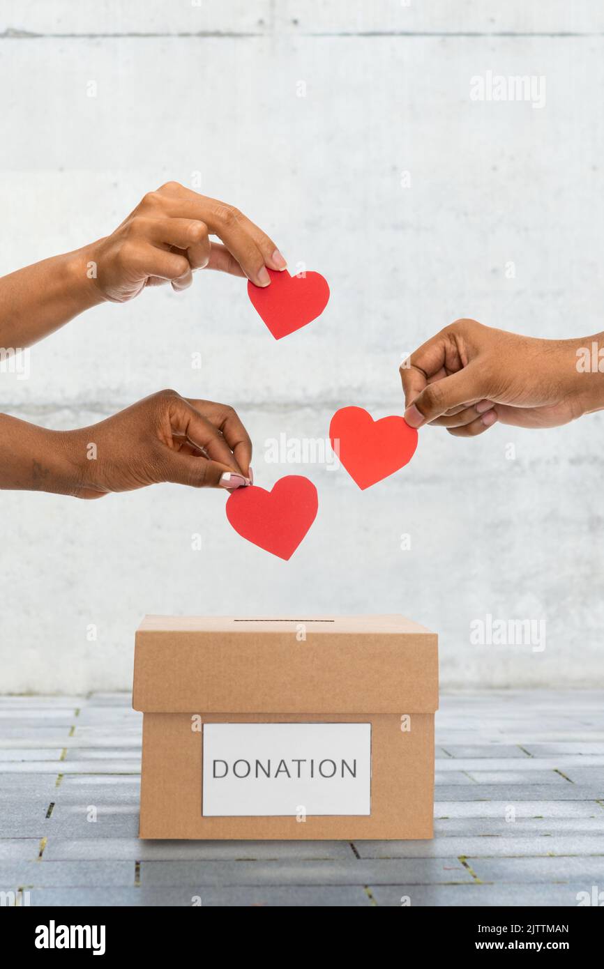 hands putting hearts into donation box on street Stock Photo - Alamy