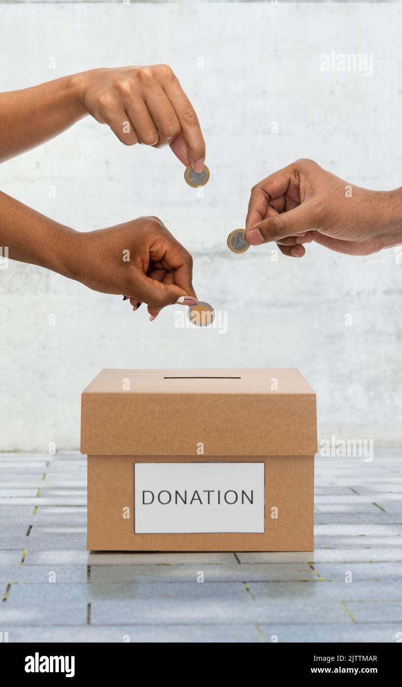 hands putting coins into donation box on street Stock Photo - Alamy