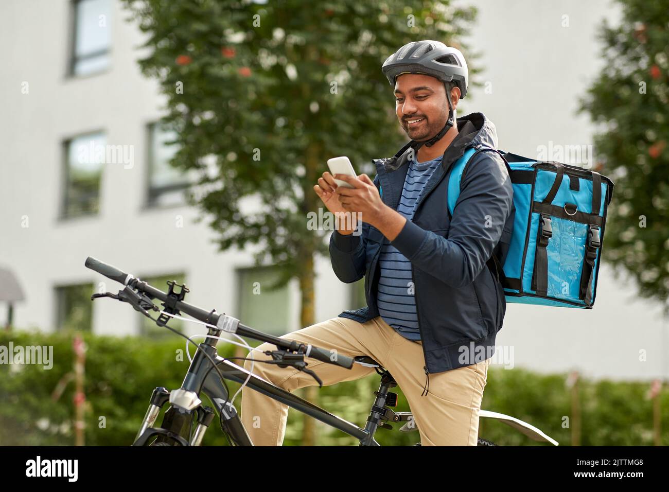 food delivery man with bag, smartphone and bicycle Stock Photo - Alamy