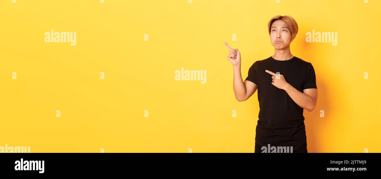 Portrait of pouting upset and funny asian guy pointing and looking ...