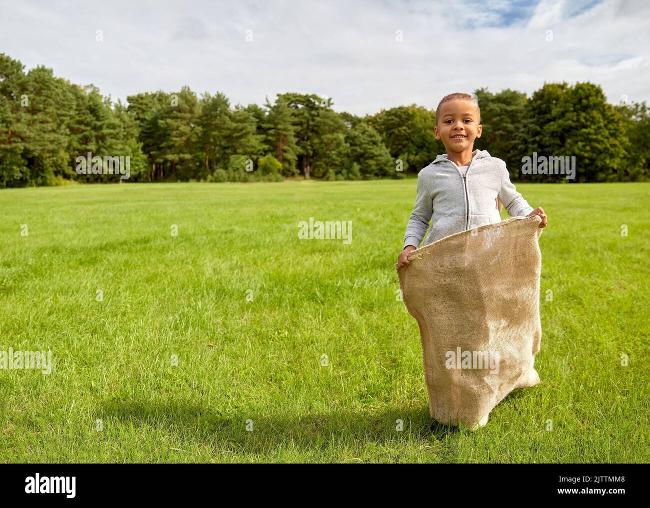 happy boy playing bag jumping game at park Stock Photo - Alamy