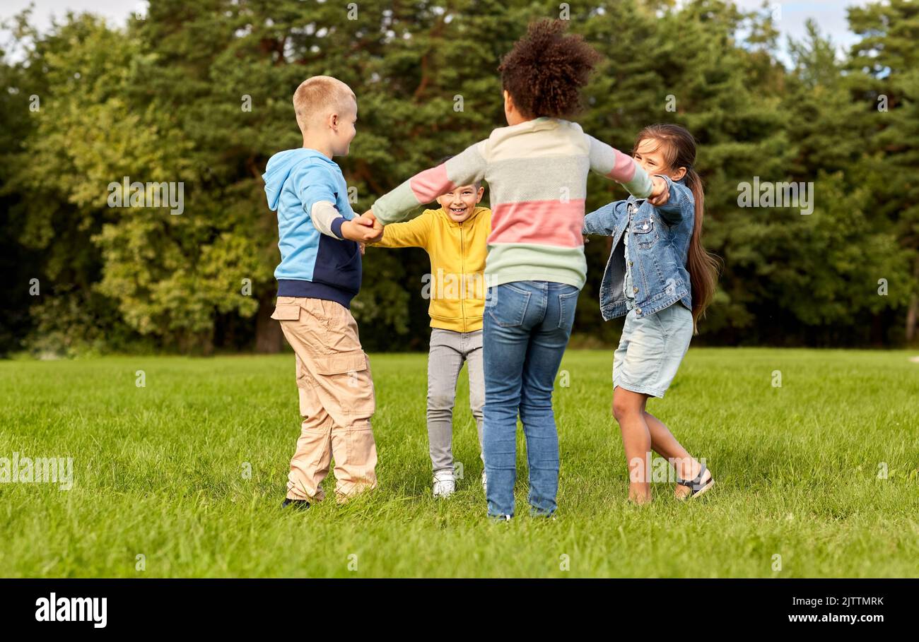 happy children playing round dance at park Stock Photo - Alamy