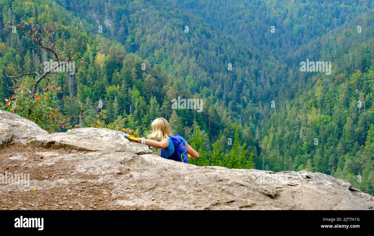The woman was climbing a stone cliff. A view of the most beautiful ...