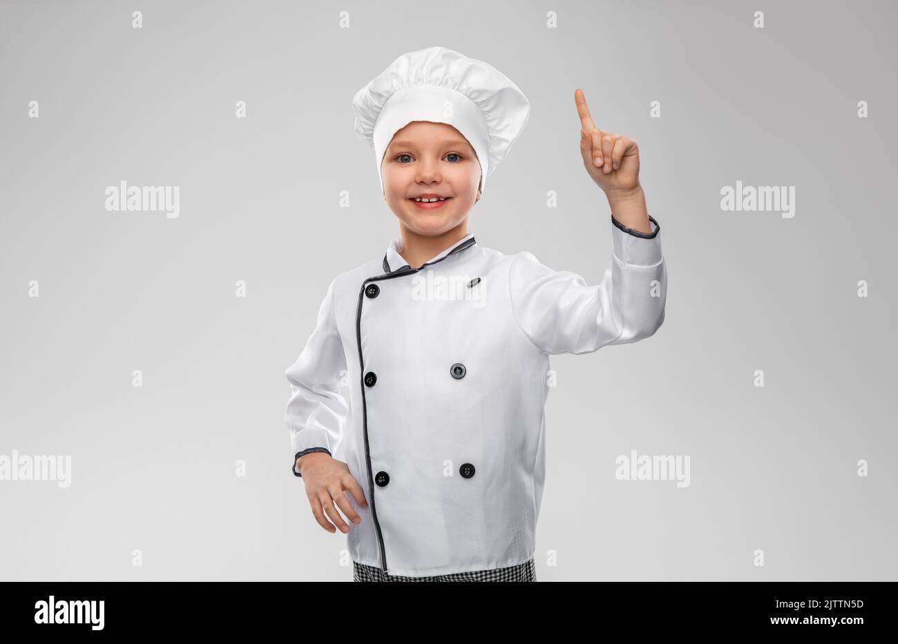 little girl in chef's toque pointing finger up Stock Photo - Alamy