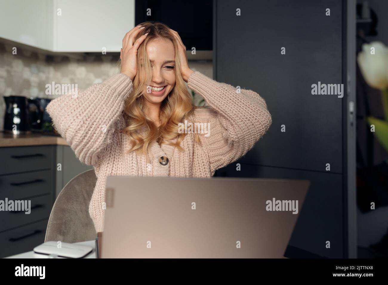 Young charming woman raised her hands to her head, experiencing joyful ...