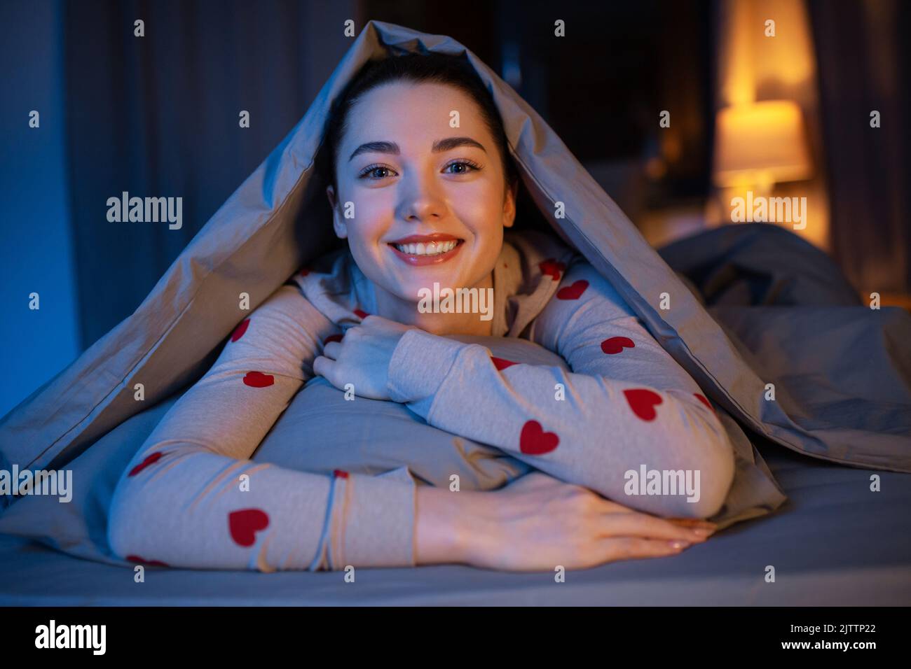 happy teenage girl lying under blanket in bed Stock Photo - Alamy