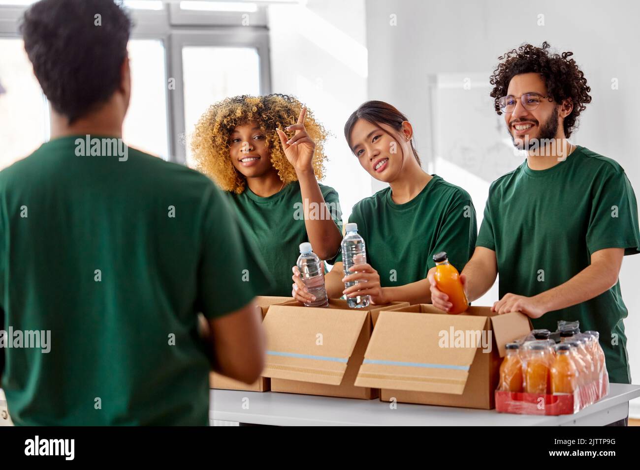 happy volunteers packing food in donation boxes Stock Photo - Alamy