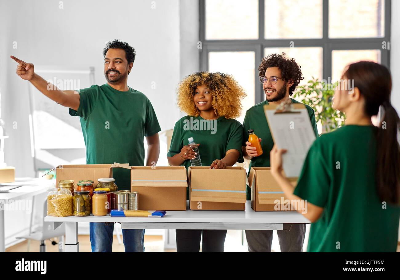 happy volunteers packing food in donation boxes Stock Photo - Alamy