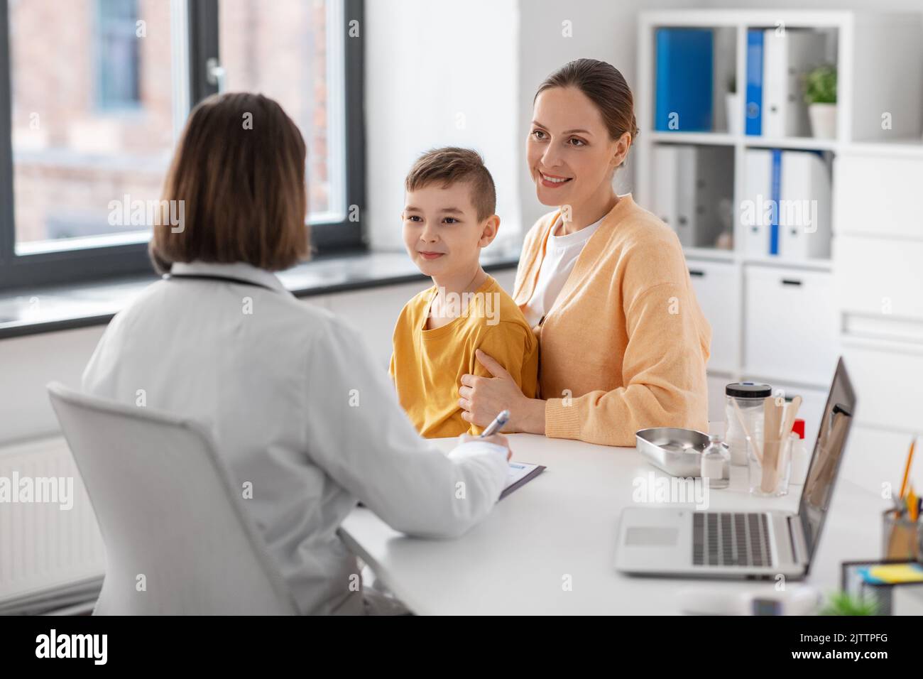 smiling mother, son and doctor talking at clinic Stock Photo - Alamy