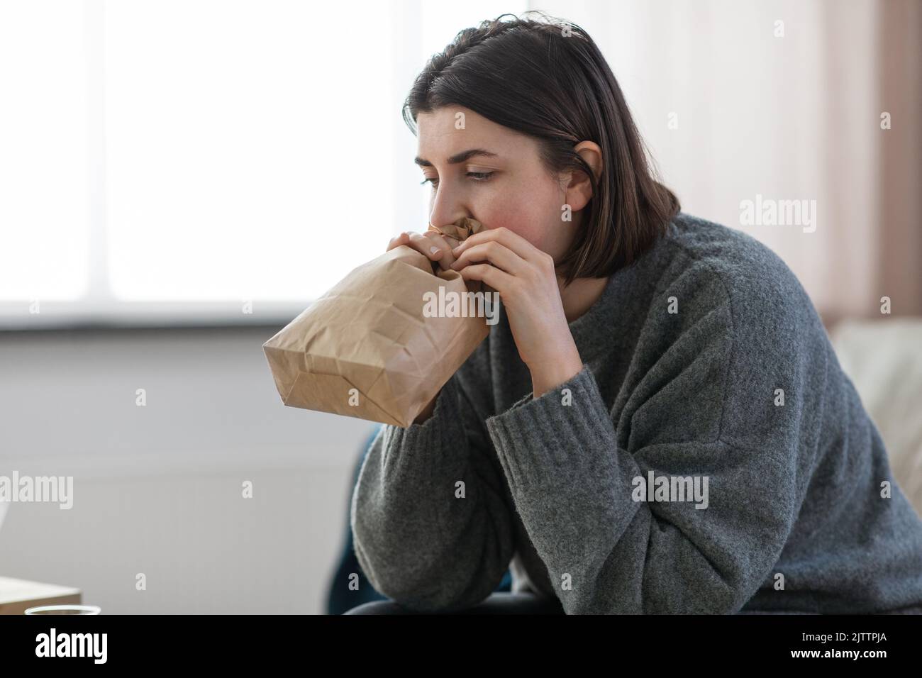 woman having panic attack breathing to bag at home Stock Photo - Alamy