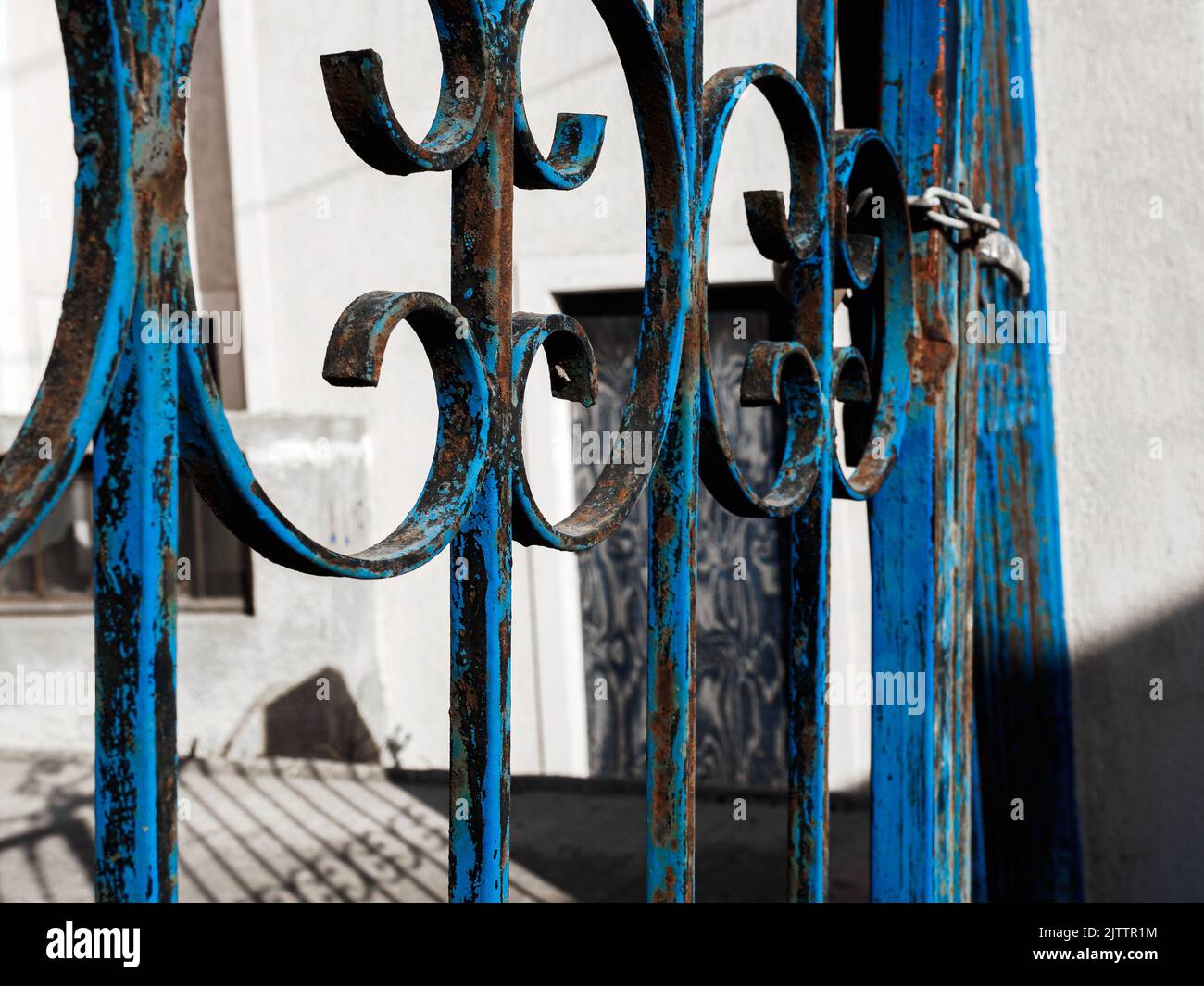 Curly details of blue peeling rusty metal gates fence Stock Photo - Alamy