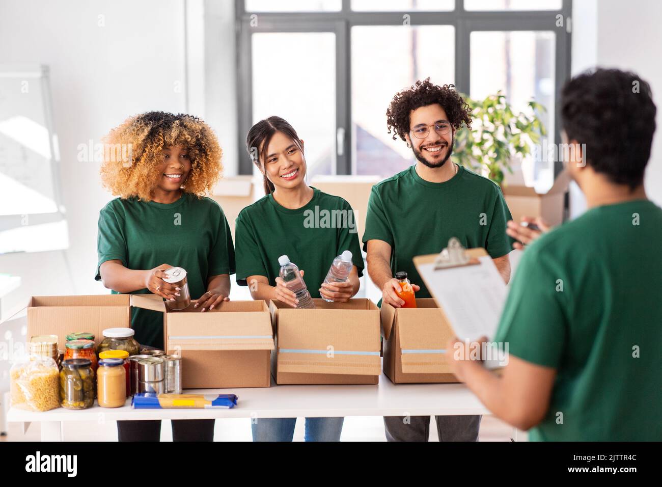 happy volunteers packing food in donation boxes Stock Photo - Alamy